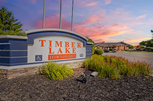Community sign with blue accents and orange letters surrounded by mulch ...