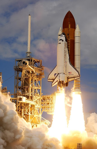 Moments after liftoff on mission STS-120 Discovery's rocket boosters spew columns of fire ...